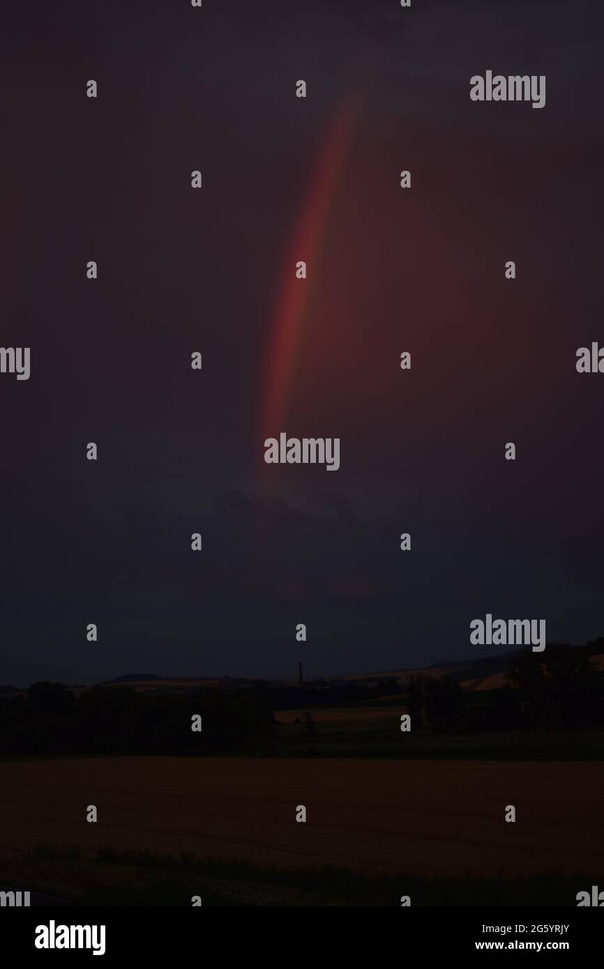 rainbow in red dusk clouds Stock Photo - Alamy