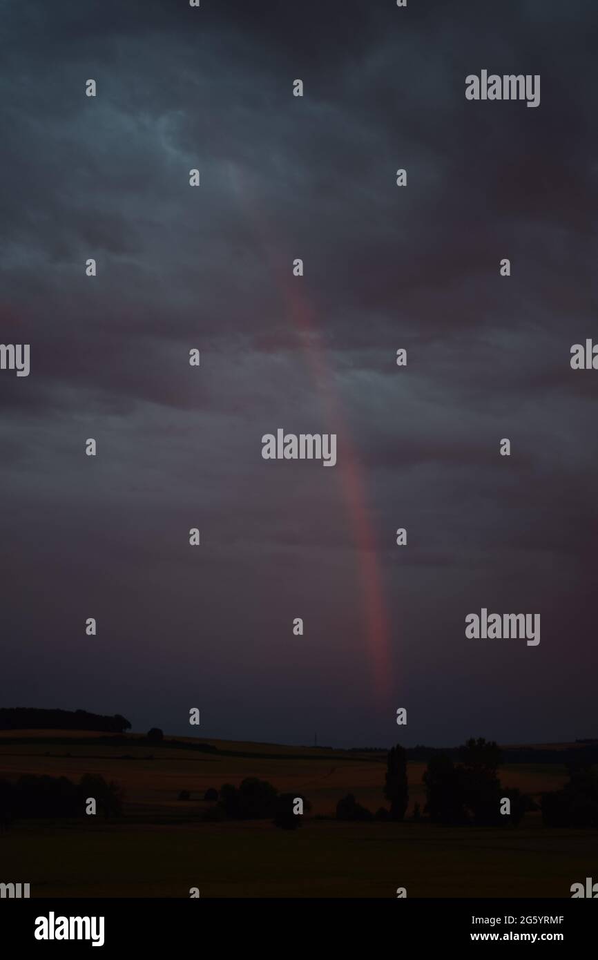 rainbow in red dusk clouds Stock Photo - Alamy