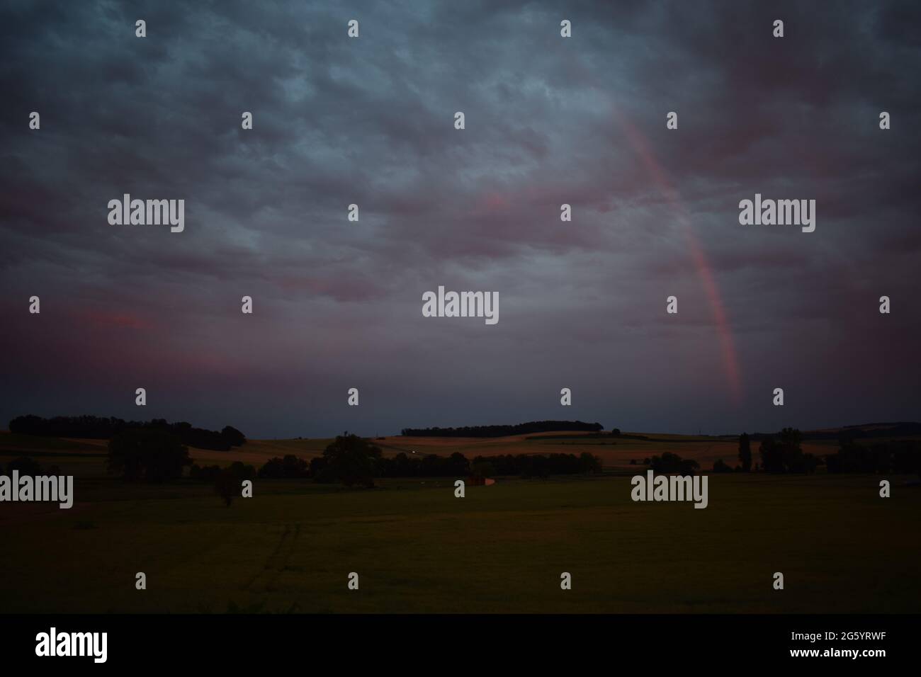 rainbow in red dusk clouds Stock Photo - Alamy