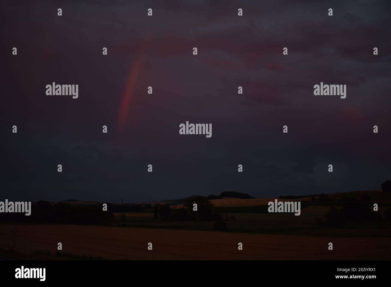 rainbow in red dusk clouds Stock Photo - Alamy