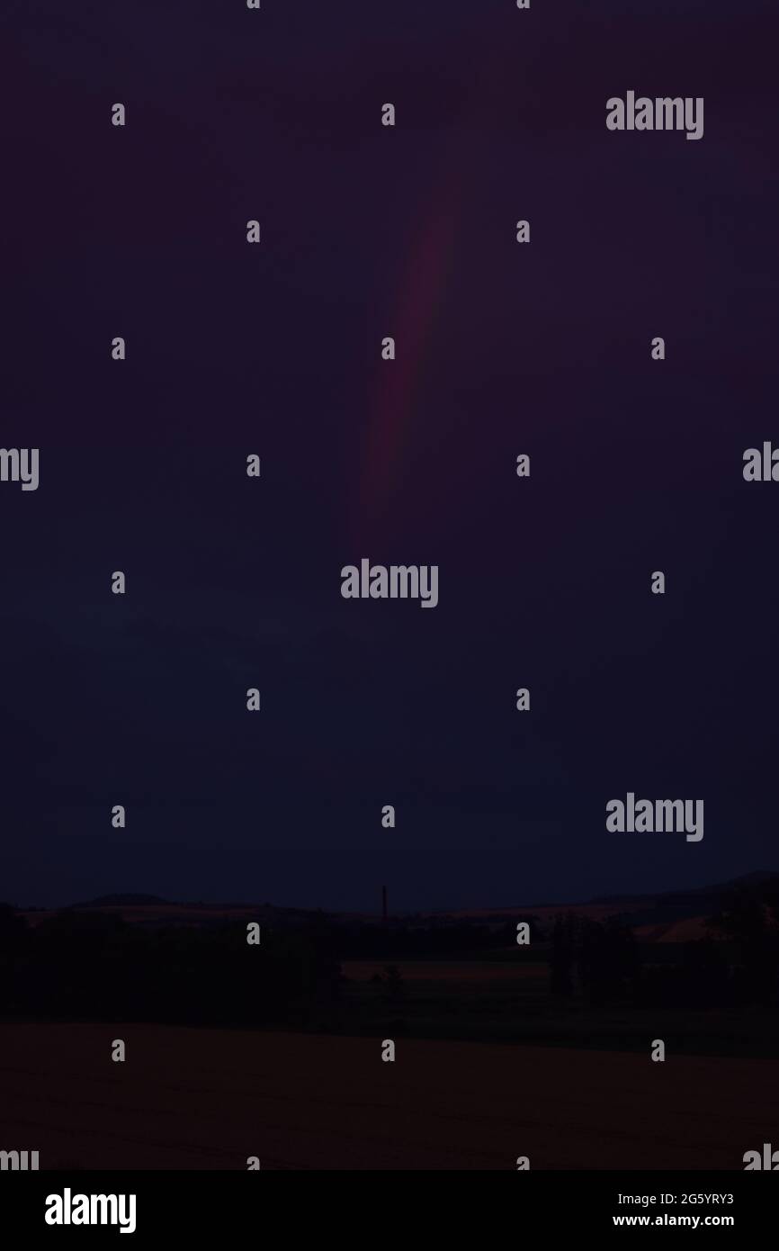 rainbow in red dusk clouds Stock Photo - Alamy