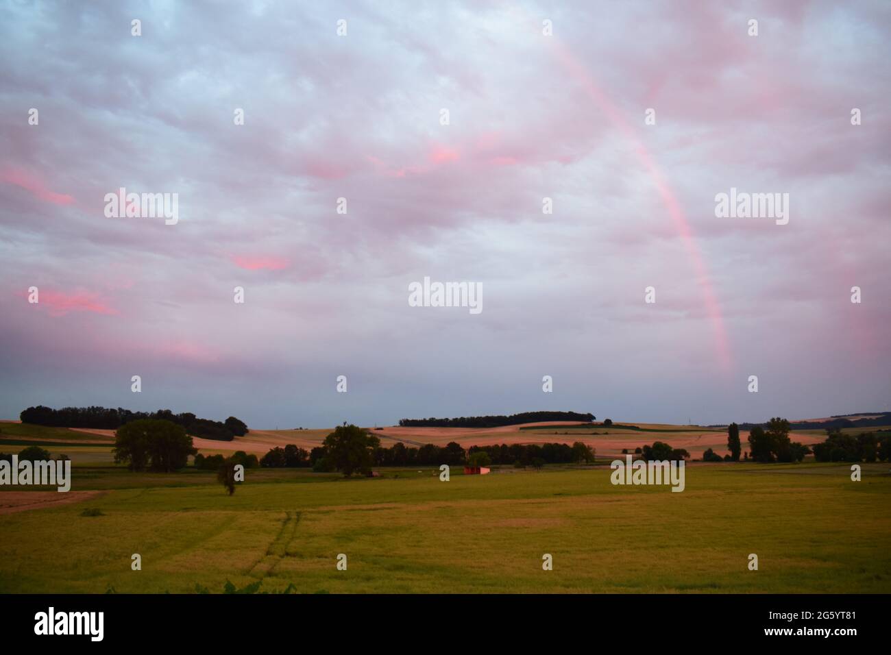 rainbow in red dusk clouds Stock Photo - Alamy