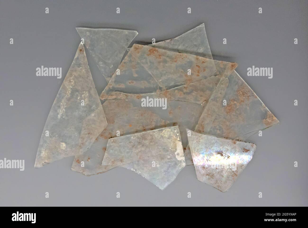 Small pile of old broken glass, isolated on vintage grey background ...