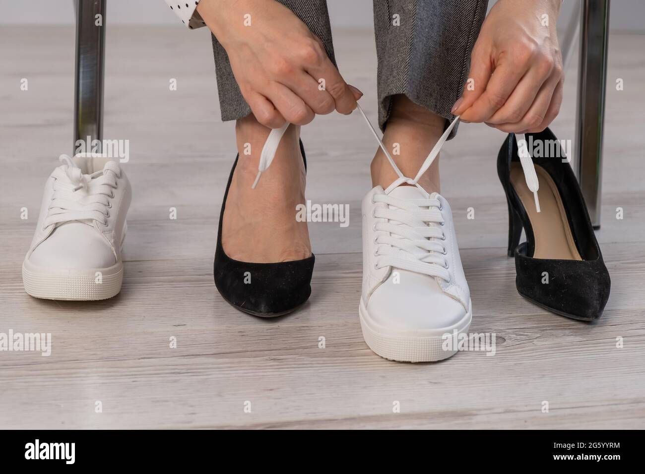 Close-up business woman takes off her shoes puts on white leather ...