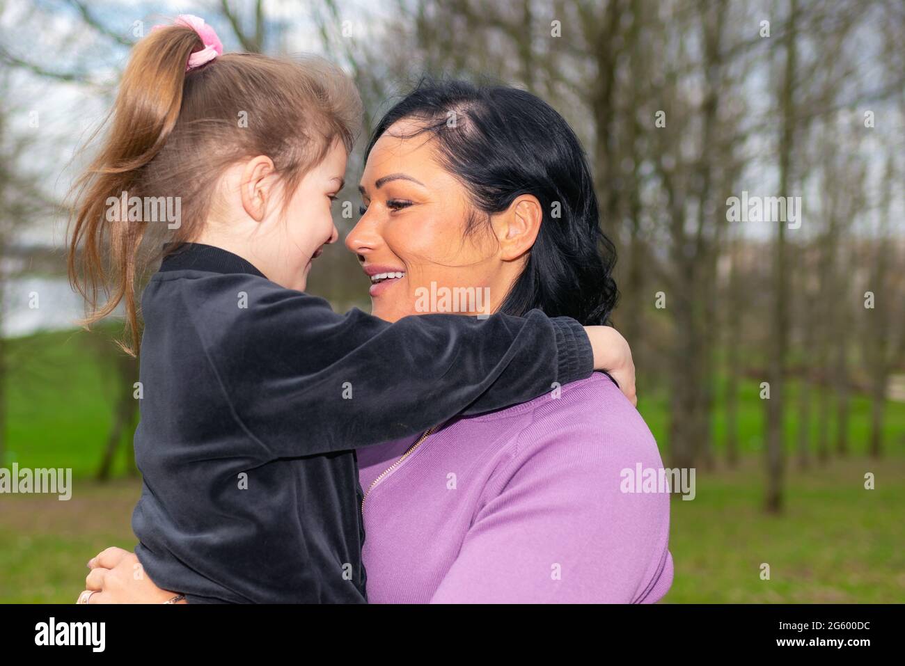 Beautiful mother and daughter play hugs in a spring park nature in ...
