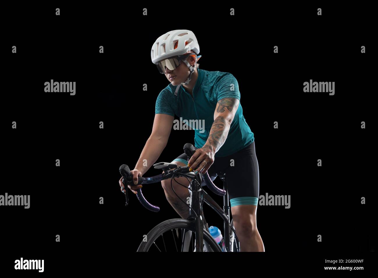 Professional young female cycler on road bike isolated over black ...