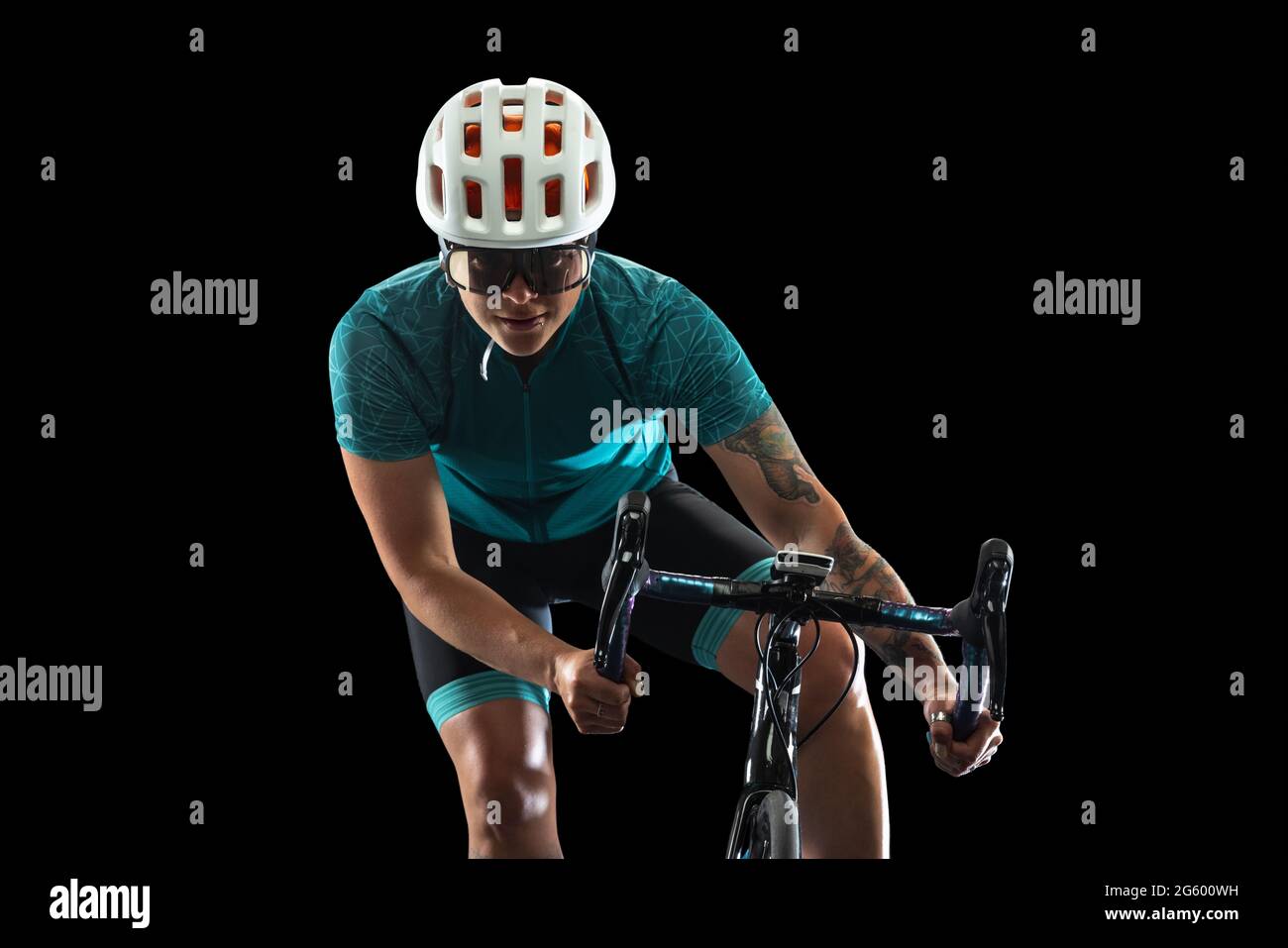 Professional young female cycler on road bike isolated over black ...