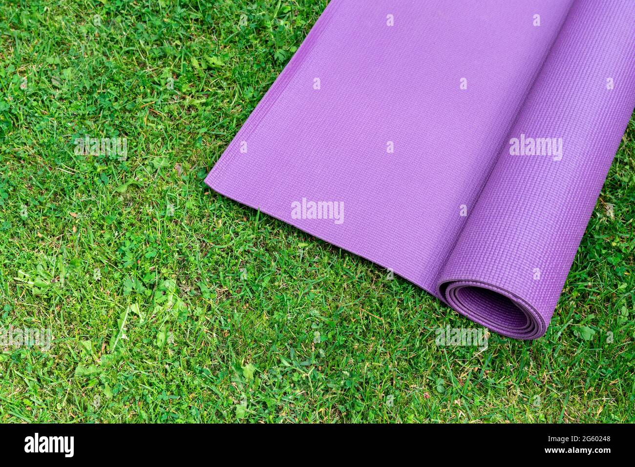 Fitness mat on the green grass background, top view. Outdoor training ...