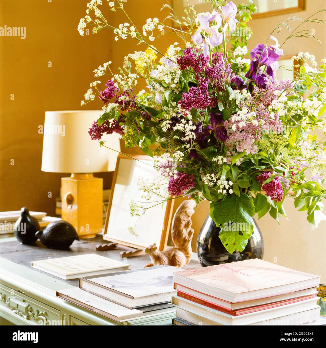 Flower arrangement and sculpture on desk Stock Photo - Alamy
