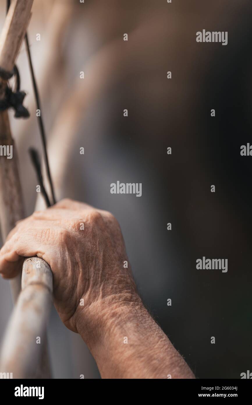 Vertical photo of the hand of an old man tying a wood structure Stock ...