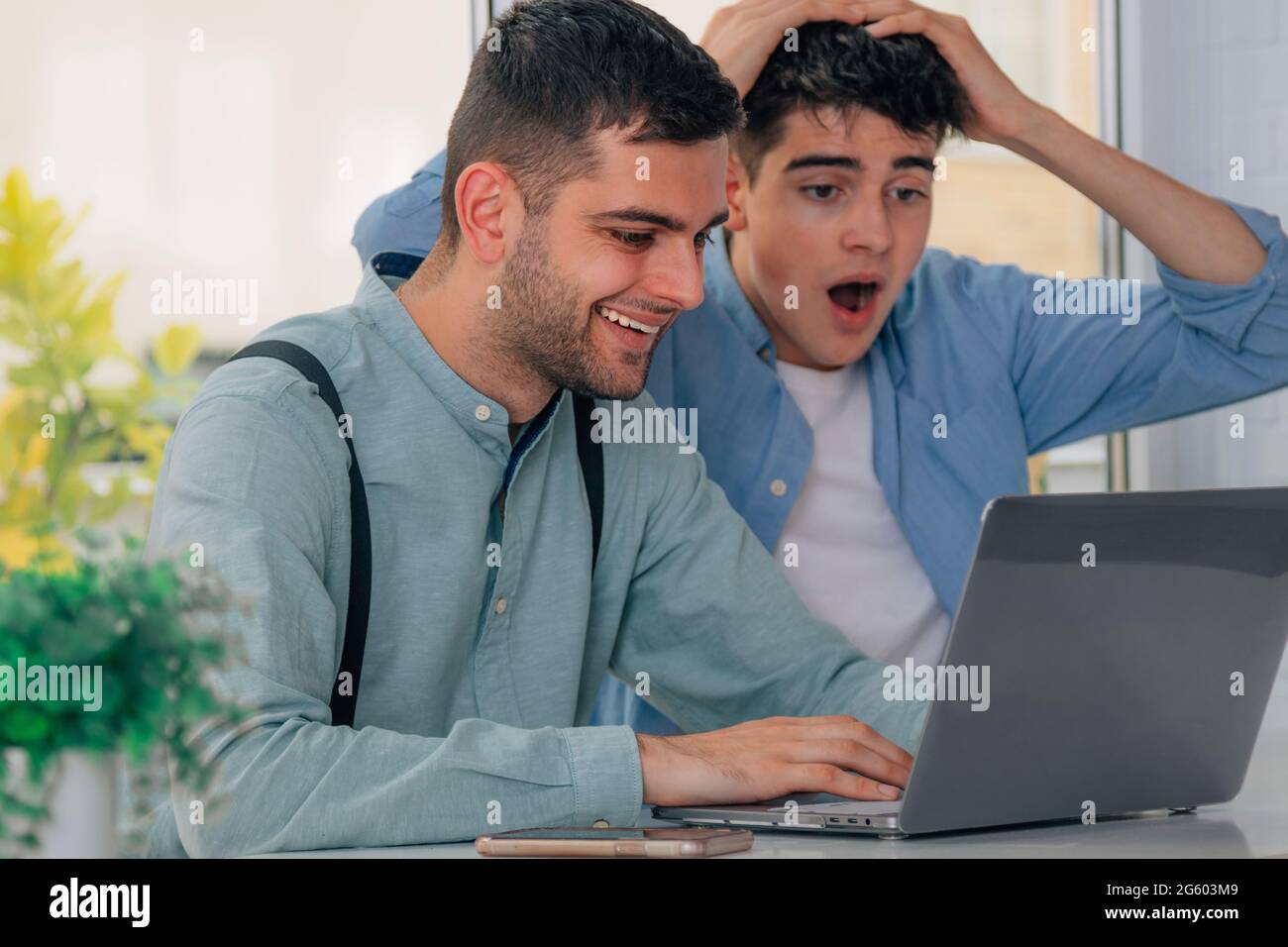young people looking at the computer in amazement Stock Photo - Alamy