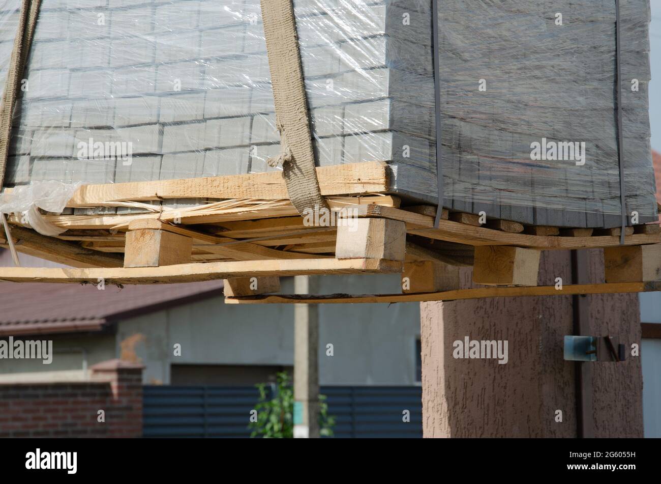 Unloading paving slabs from a truck. Men unload paving slabs using a ...
