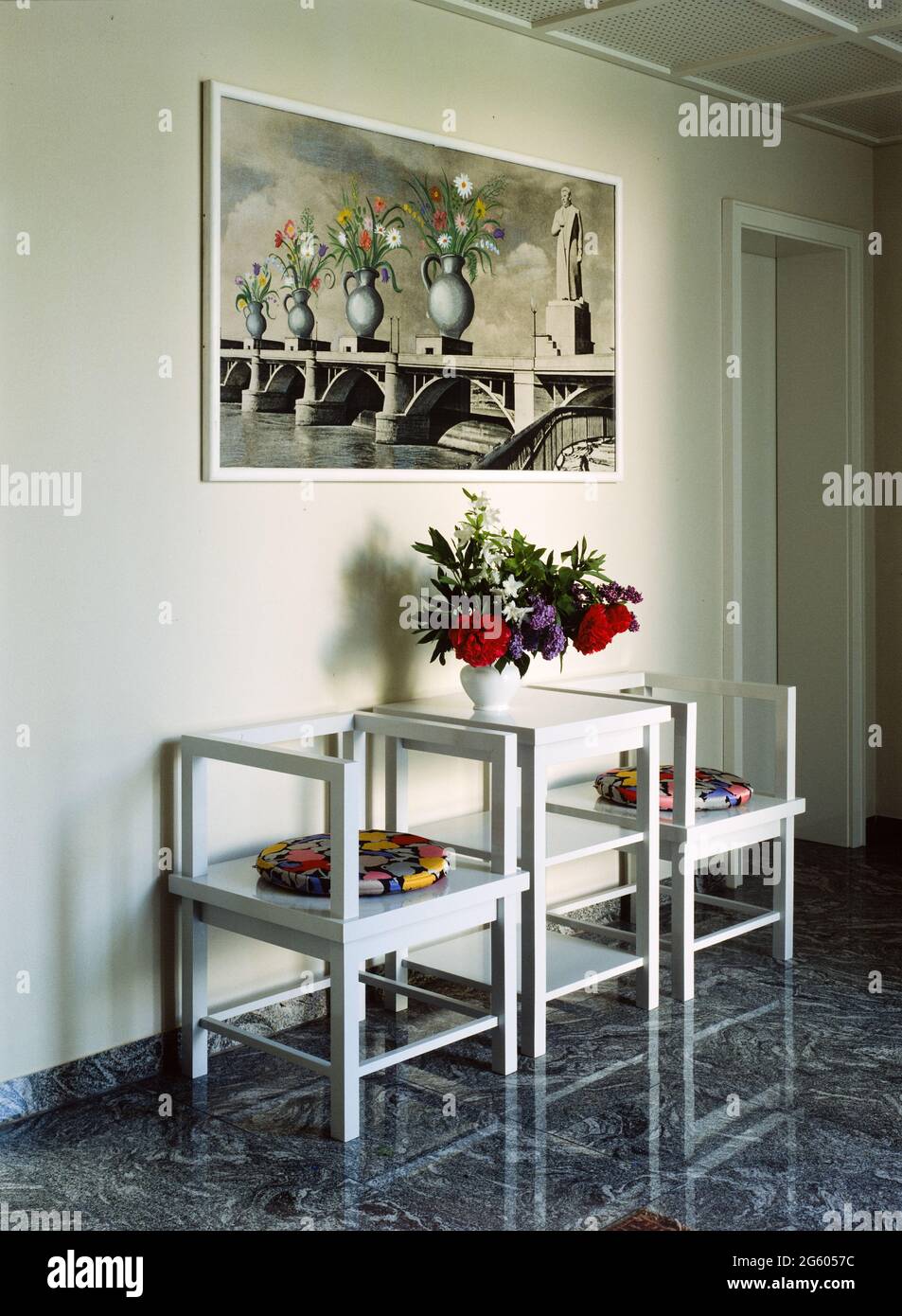 Armchairs and table under painting Stock Photo - Alamy