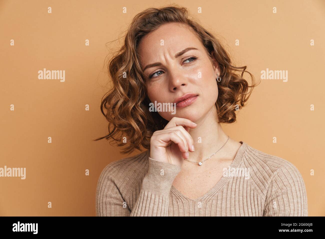 Young ginger puzzled woman frowning and looking aside isolated over ...