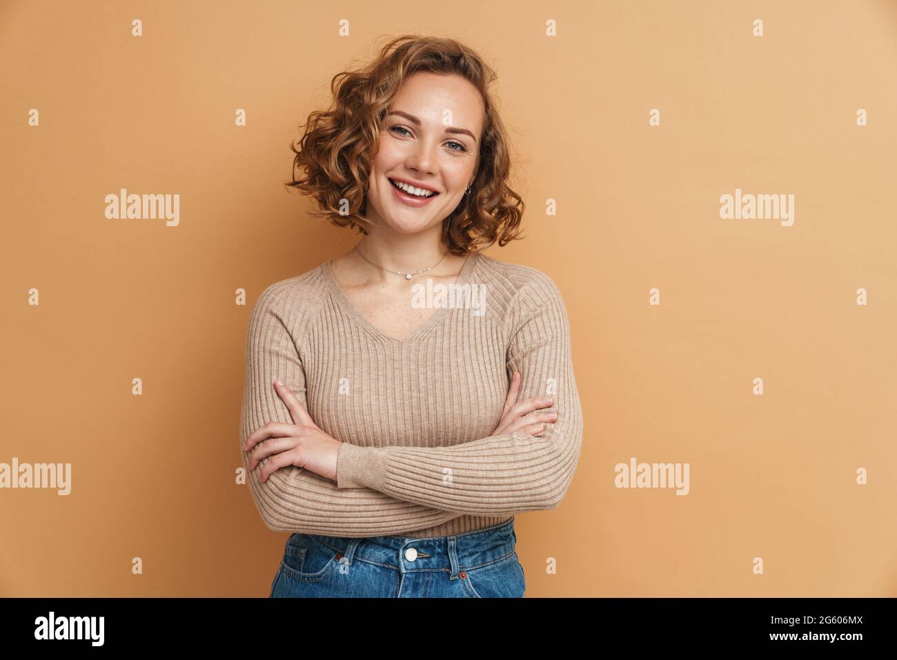 Young ginger woman smiling while posing with arms crossed isolated over ...