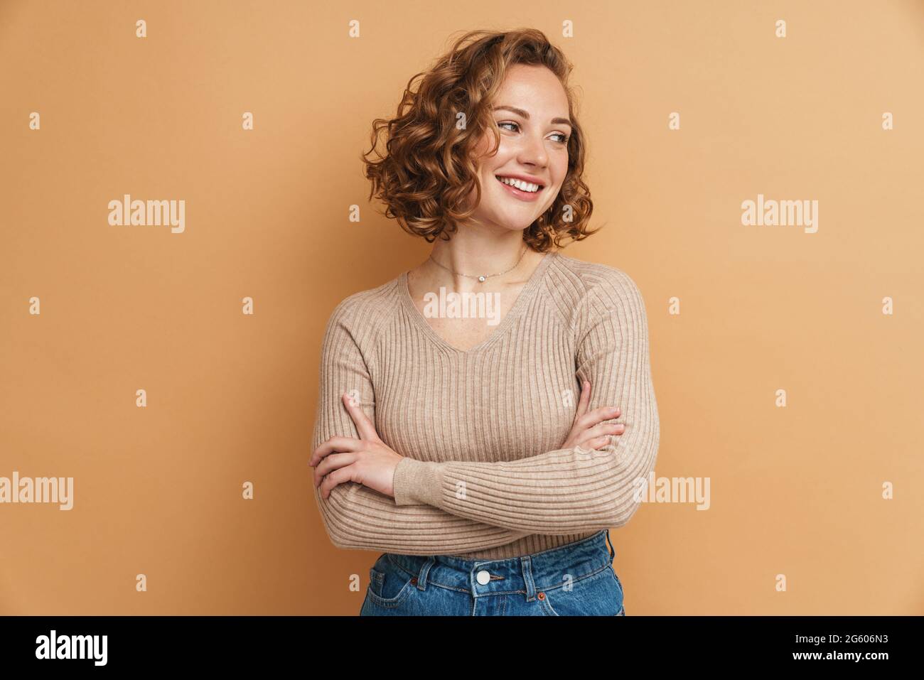 Young ginger woman smiling while posing with arms crossed isolated over ...