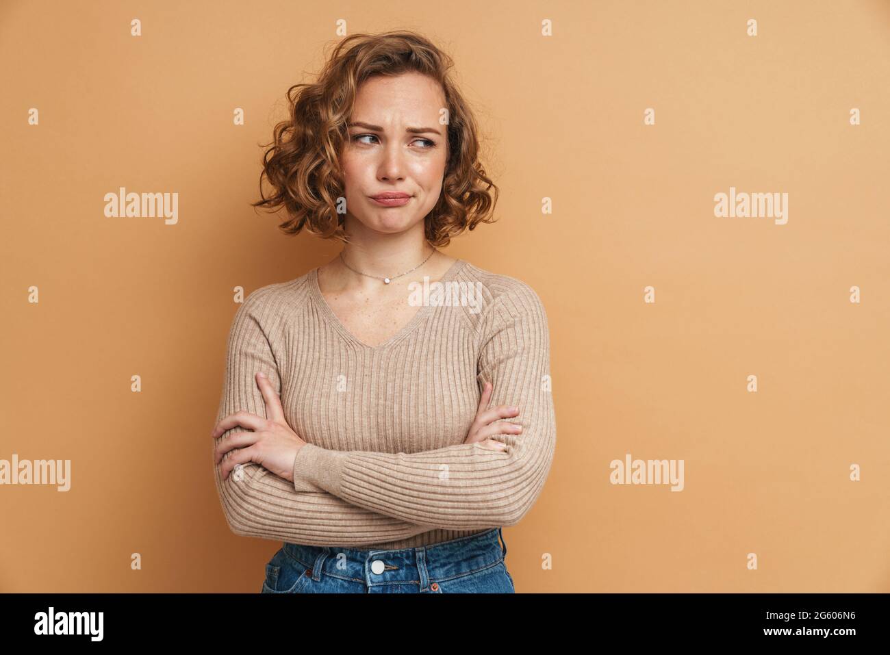 Sad ginger woman frowning while posing with arms crossed isolated over ...