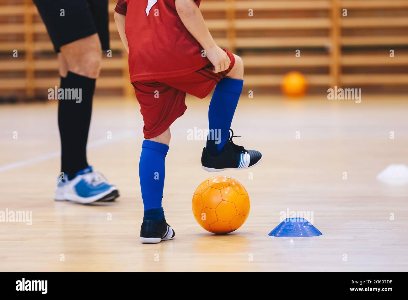 Boy in Soccer Clothes with Ornage Futsal Ball. Kid on indoor soccer ...