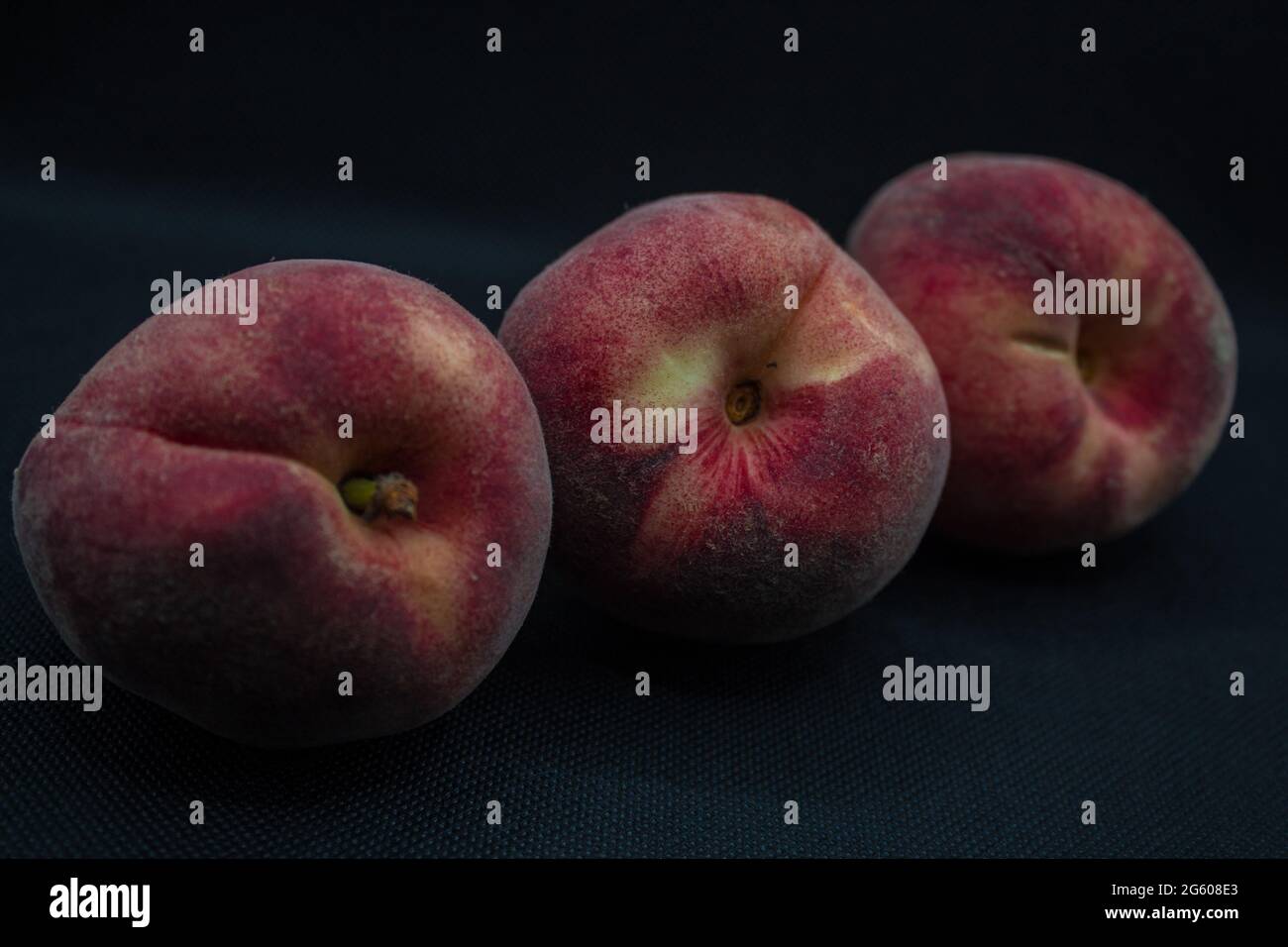 Red peach isolated on a black background Stock Photo - Alamy