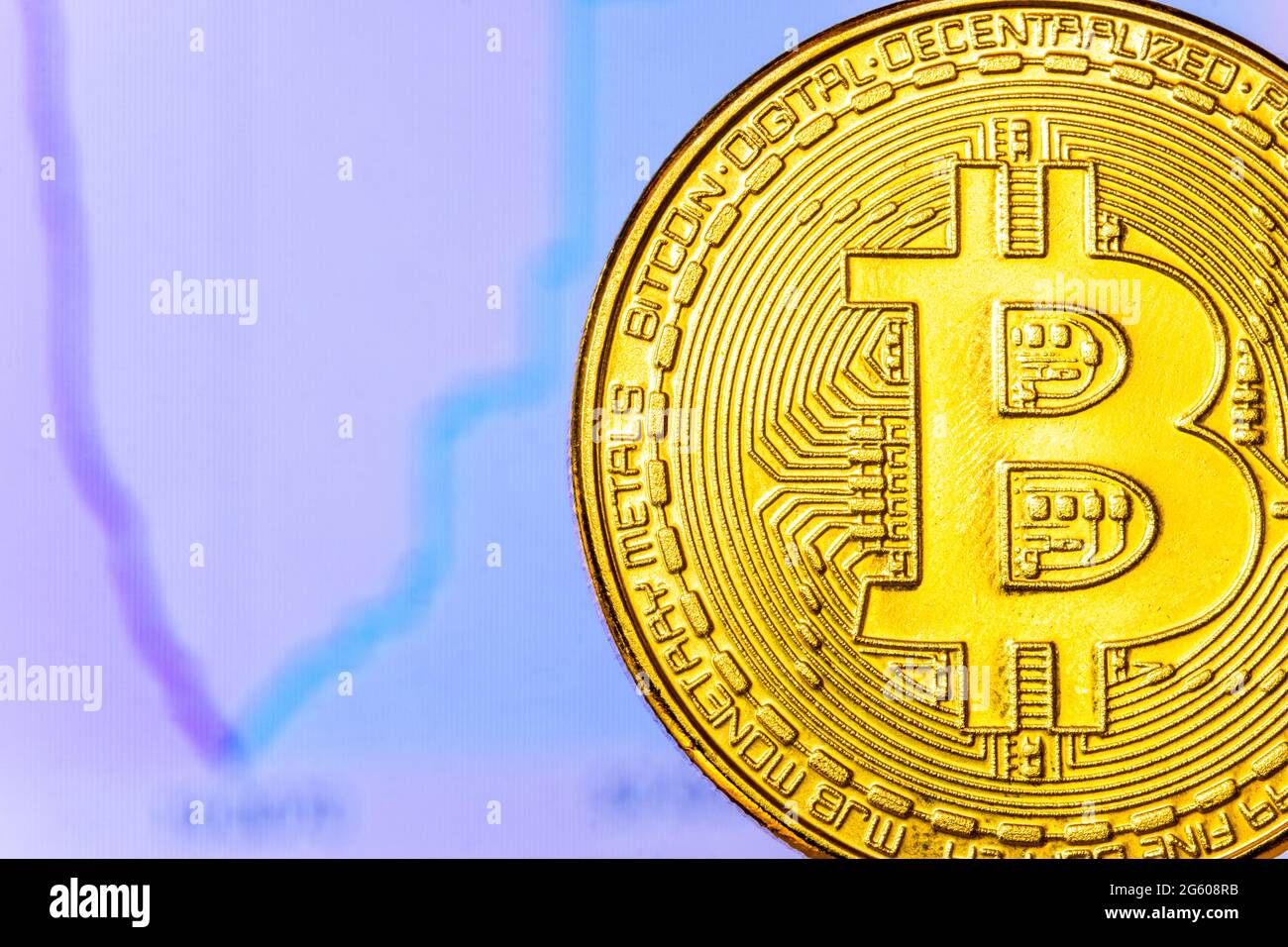 Bitcoin virtual currency in front of a screen with currency movement ...