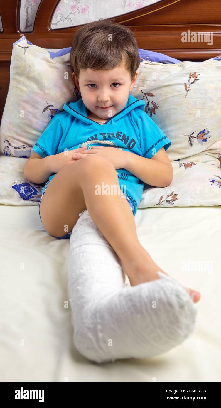 A little boy with a broken leg is lying on the bed Stock Photo - Alamy