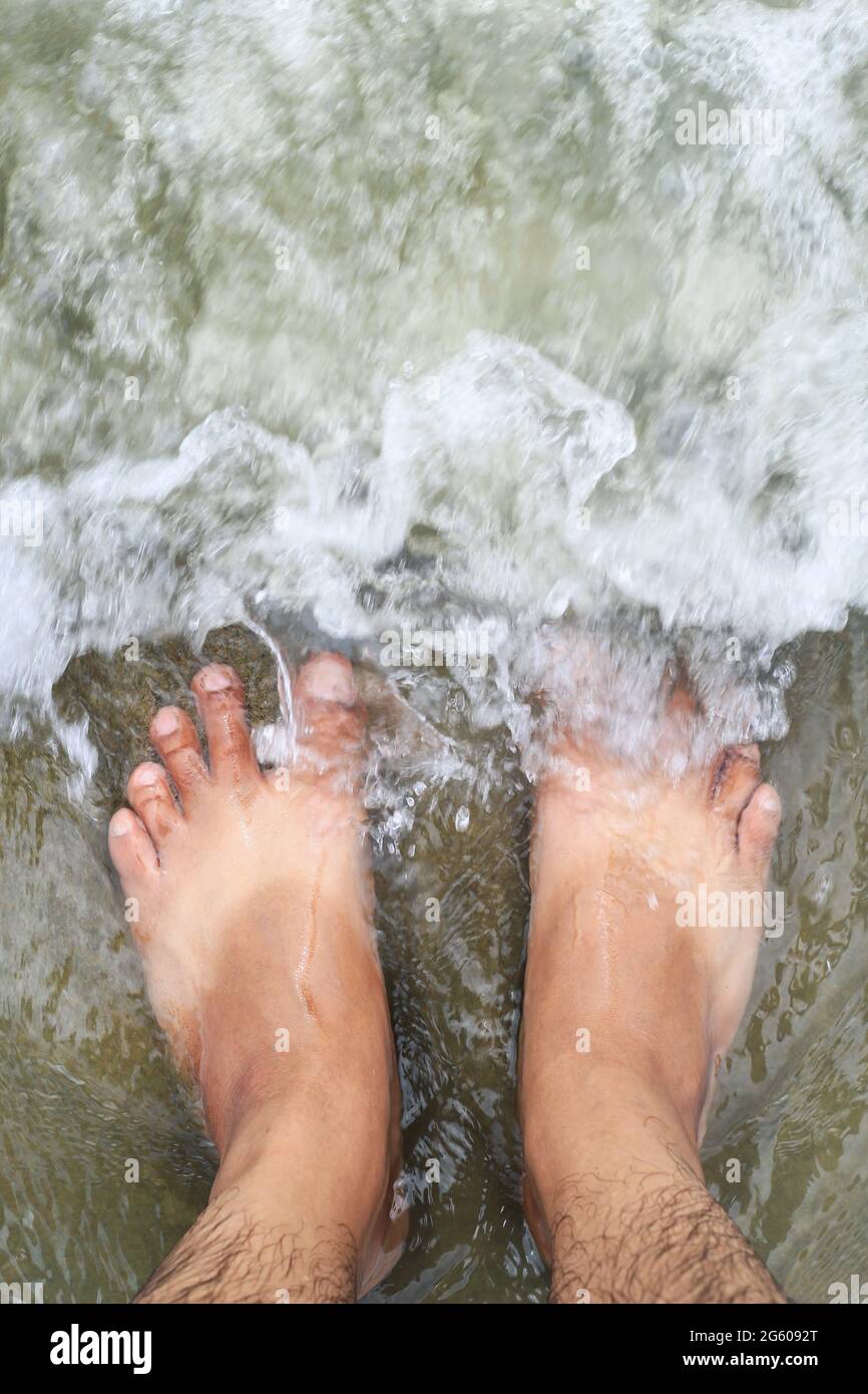Vacation on the ocean beach, feet on the sea sand. Standing on the ...