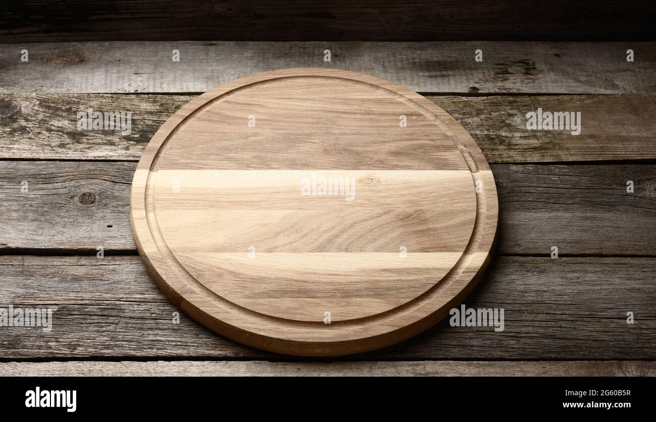 empty round wooden cutting kitchen board on wooden background, pizza ...