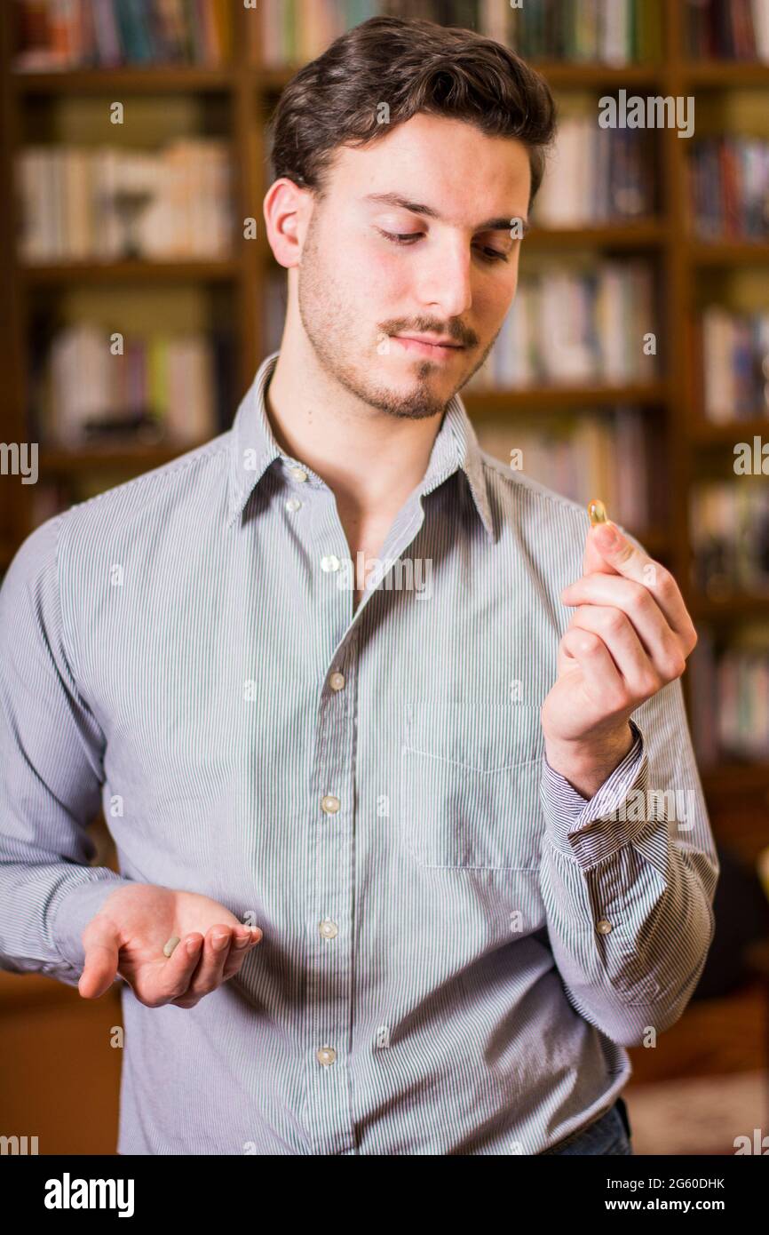 Man at home taking medicine tablet or pill Stock Photo - Alamy