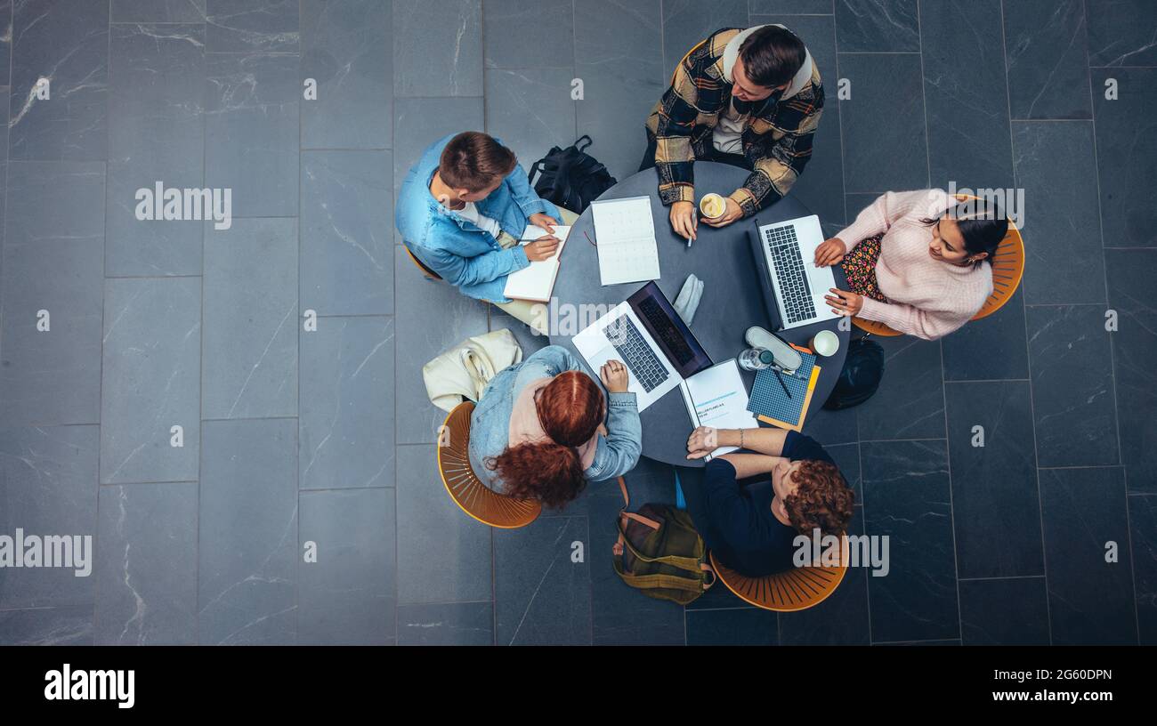 Overhead shot of students studying for exam in university. Young men ...
