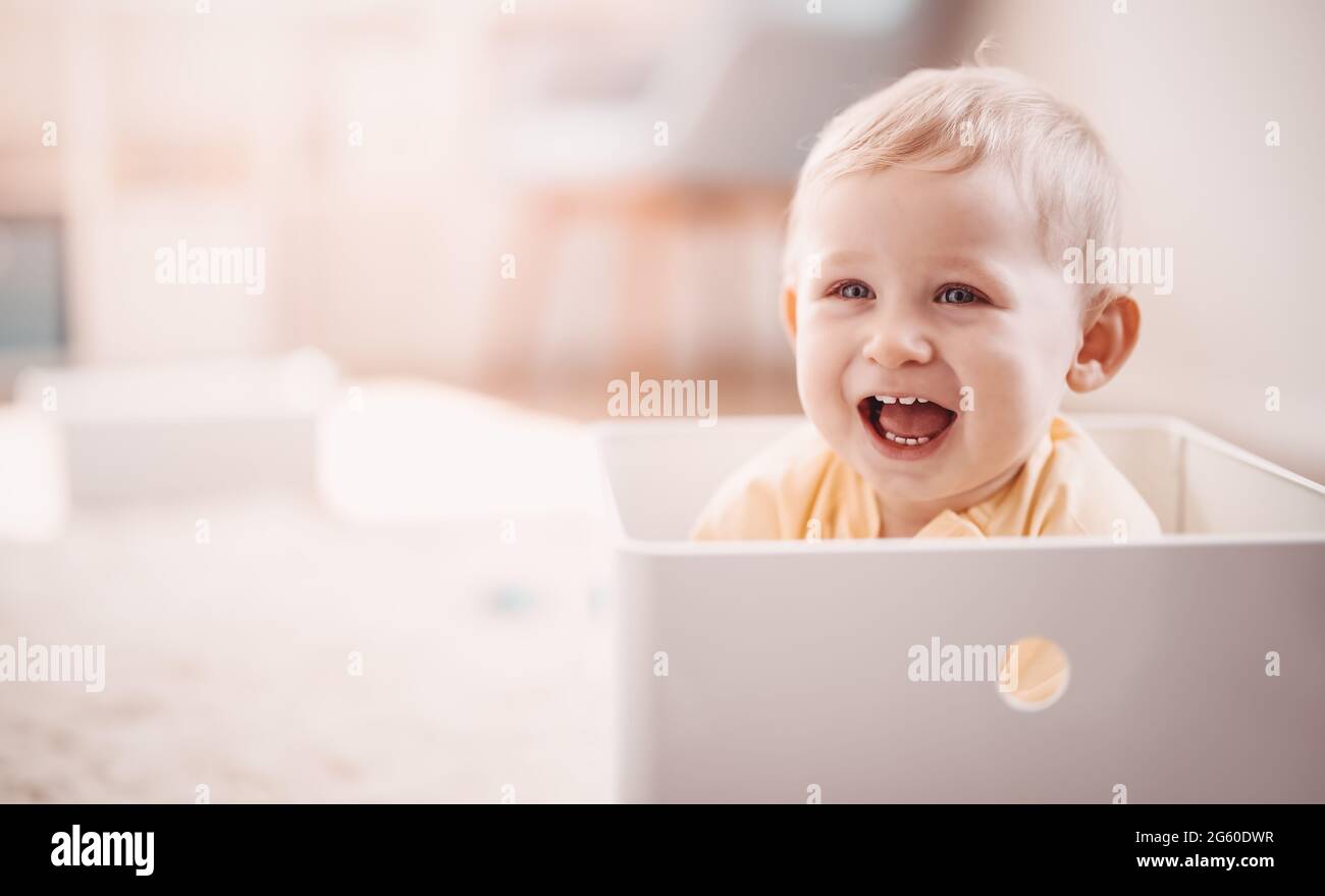 Cute boy sitting in the white plastic box Stock Photo - Alamy