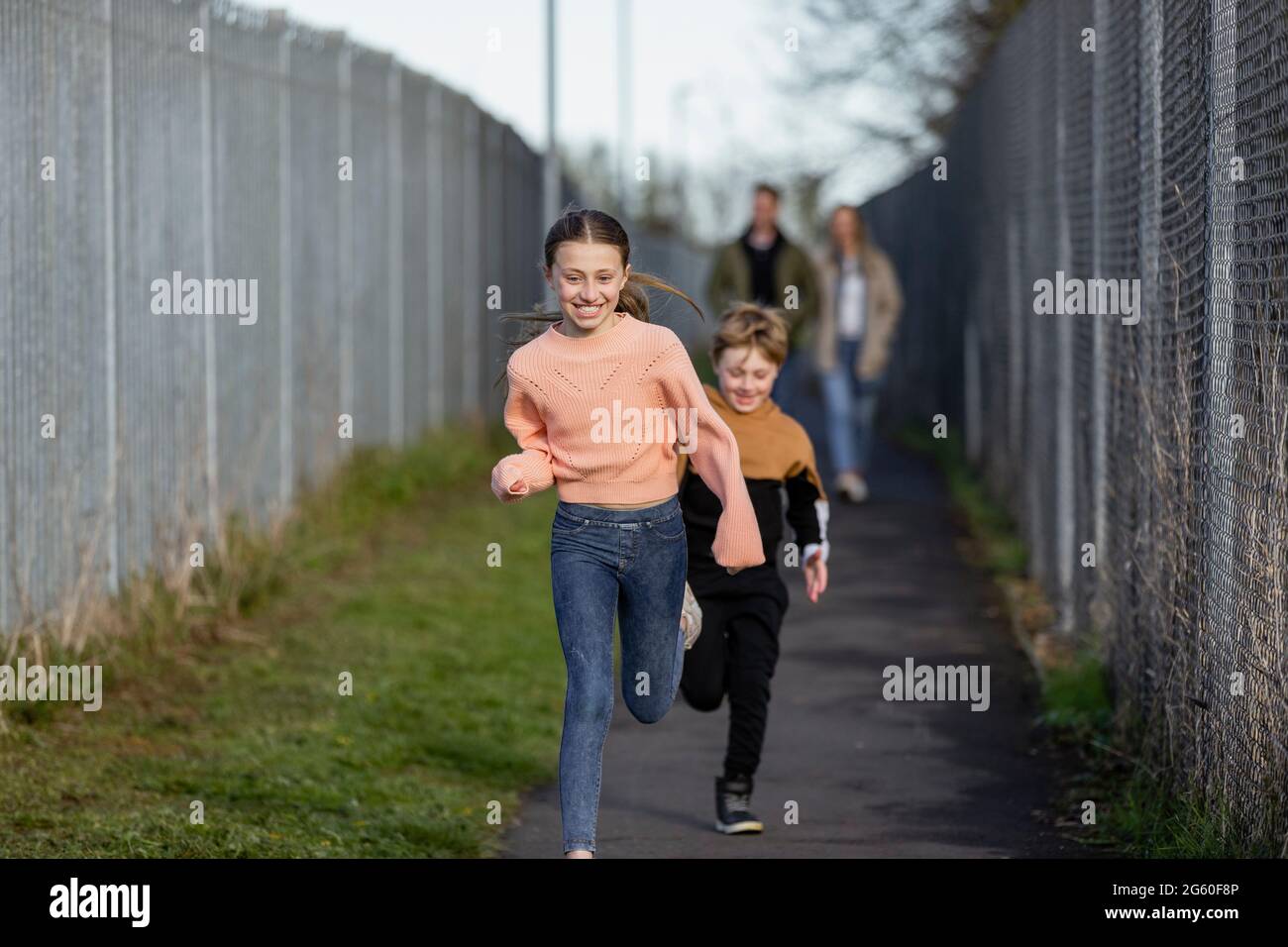 A front-view shot of a caucasian mother and father walking along a ...
