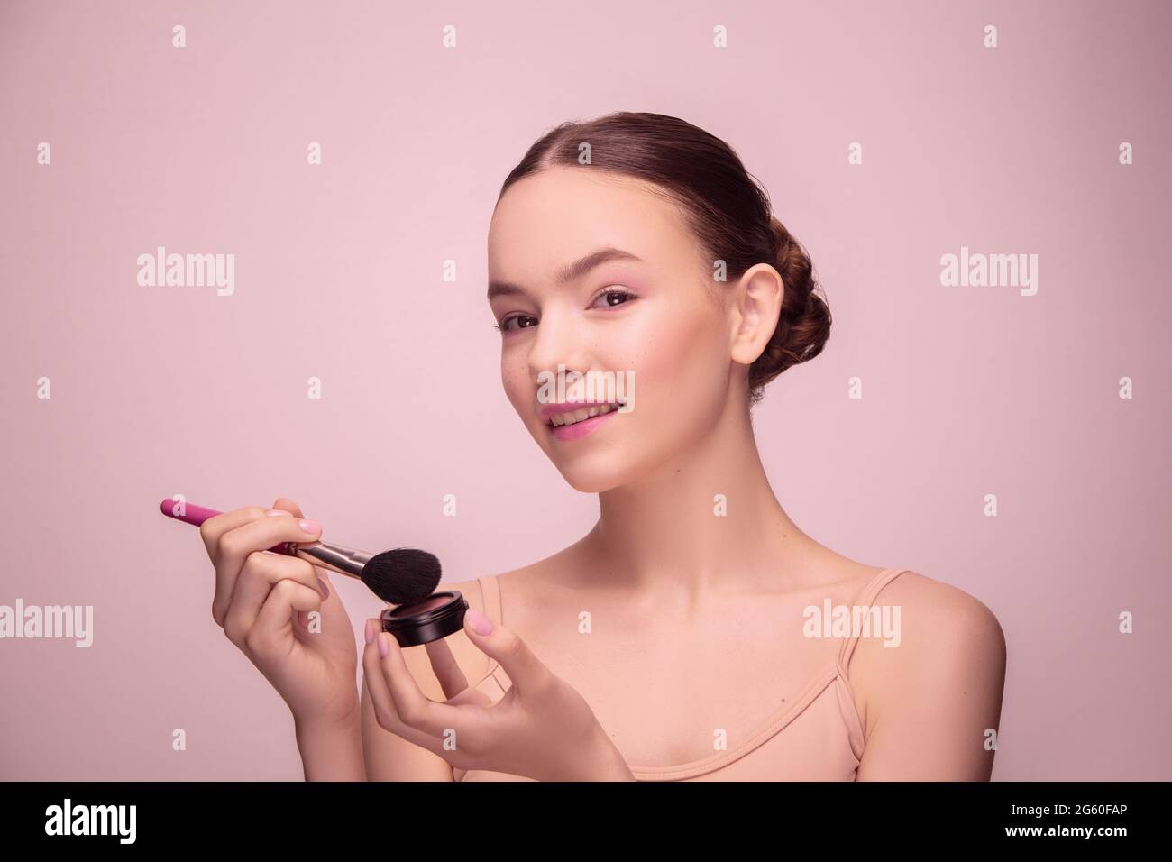 Portrait of beautiful young woman isolated on light pink studio ...