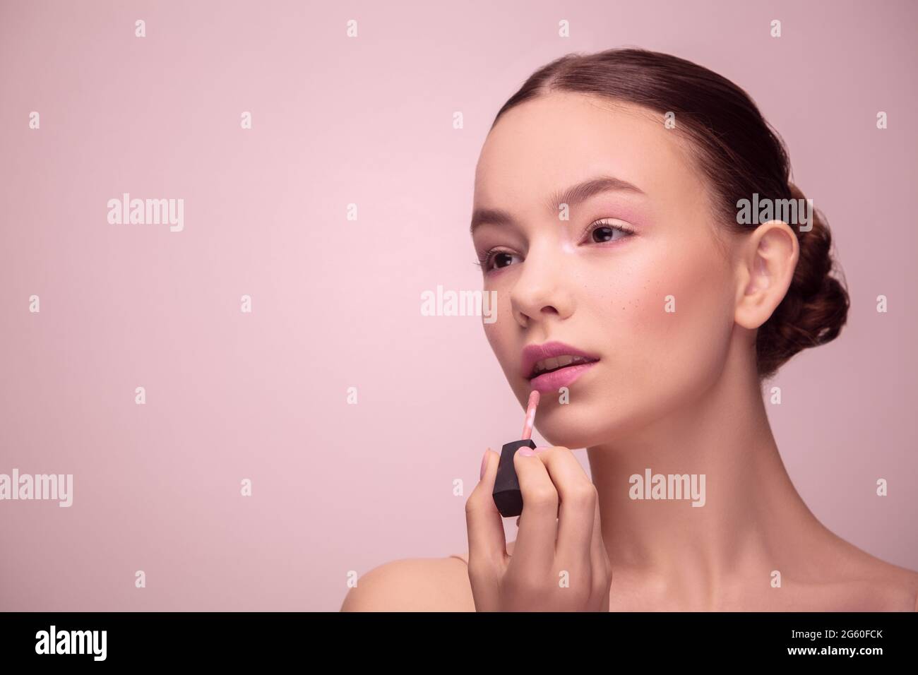Portrait of beautiful young woman isolated on light pink studio ...