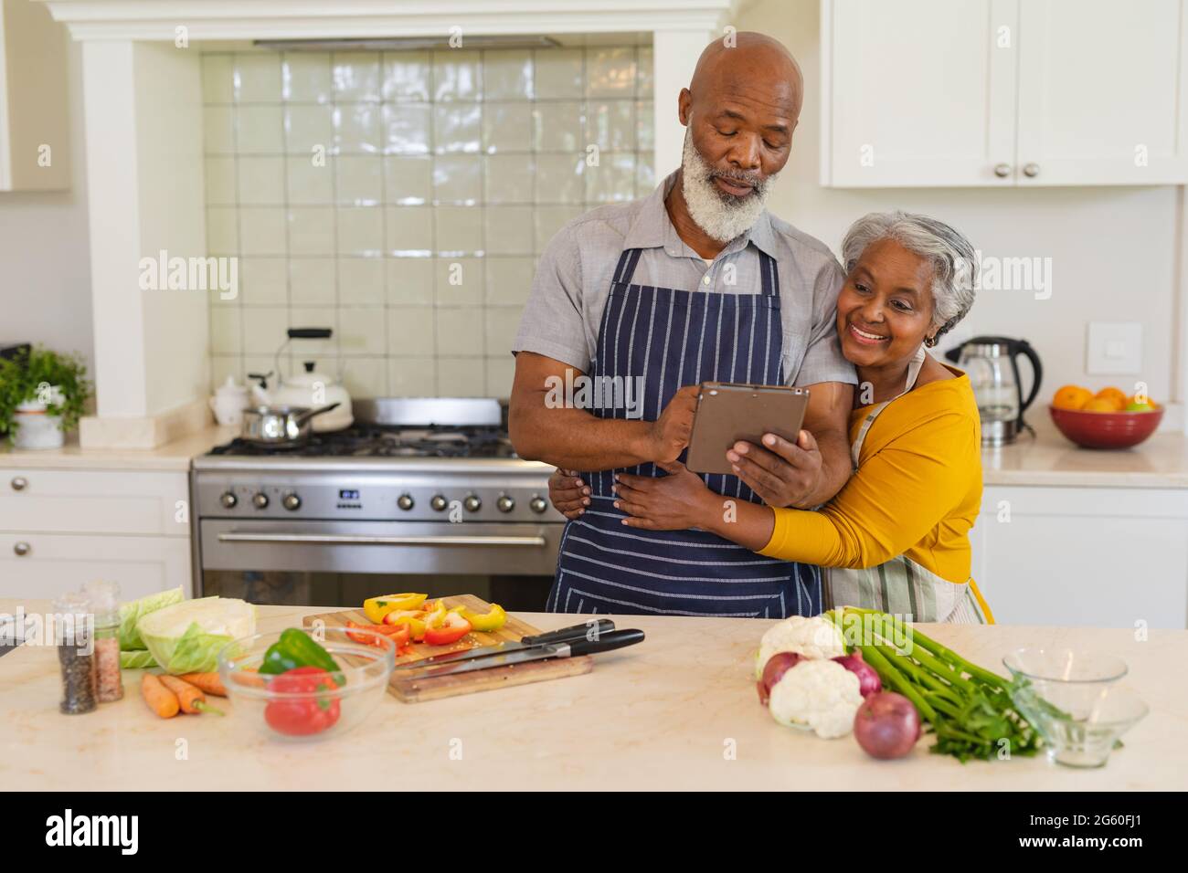 Senior african american couple cooking together in kitchen using tablet ...