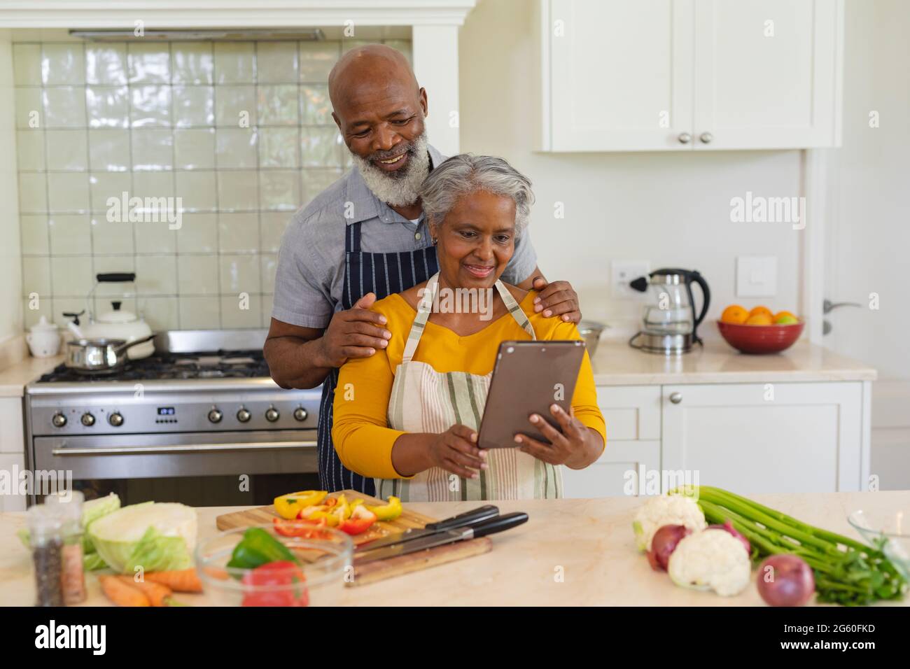 Senior african american couple cooking together in kitchen using tablet ...