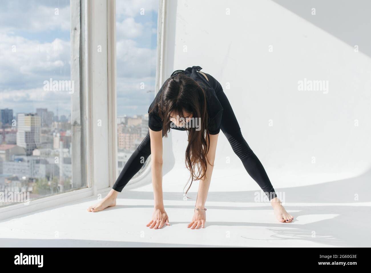 barefoot armenian woman practicing pyramid pose near window Stock Photo ...