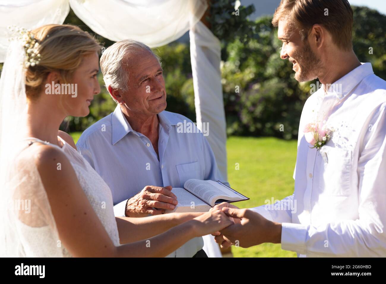 Happy caucasian bride and groom getting married holding hands vowing ...