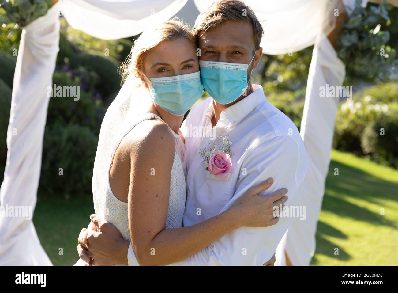 Portrait of happy caucasian bride and groom getting married wearing ...