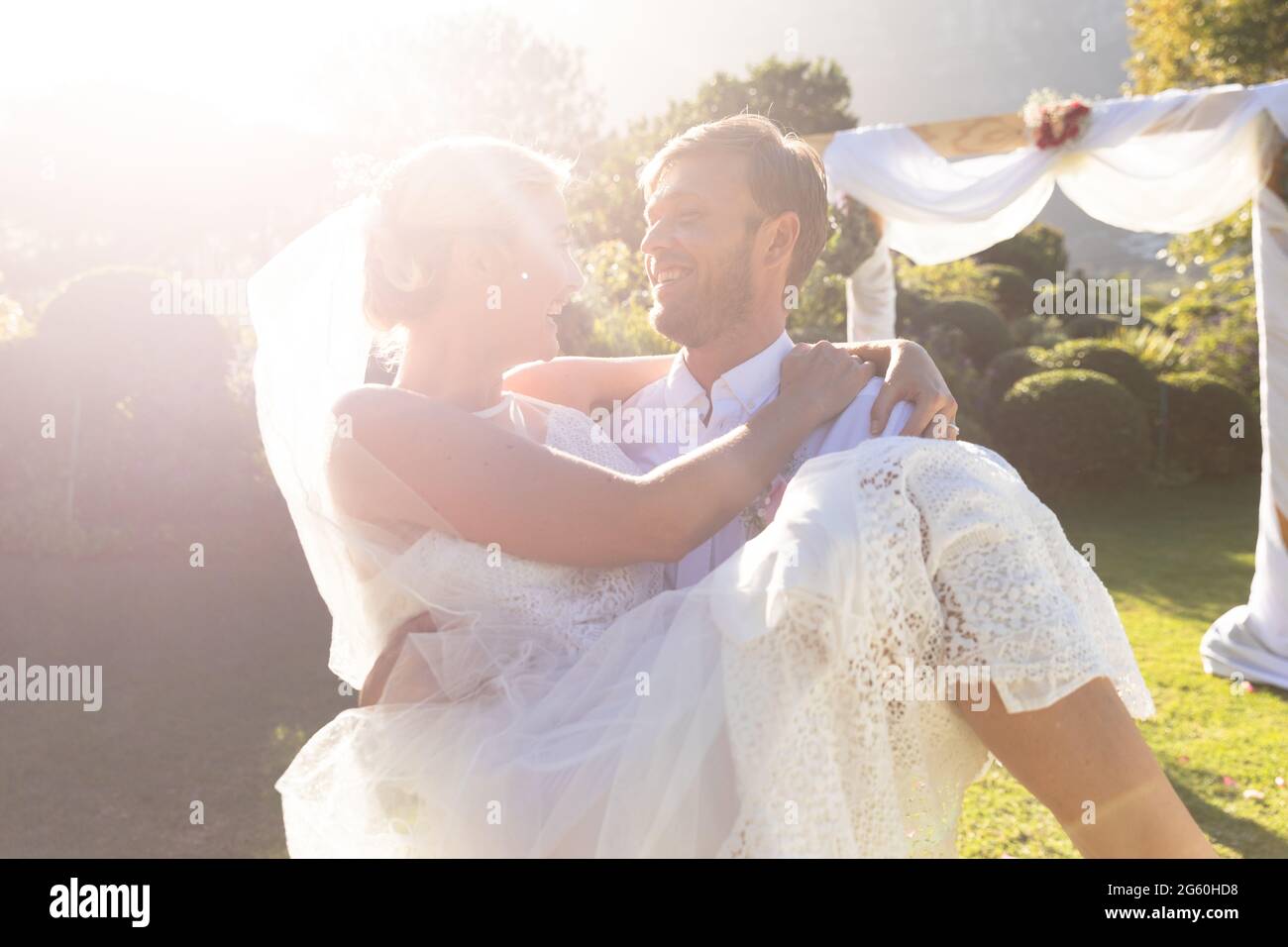 Happy caucasian bride and groom getting married, groom carrying bride ...