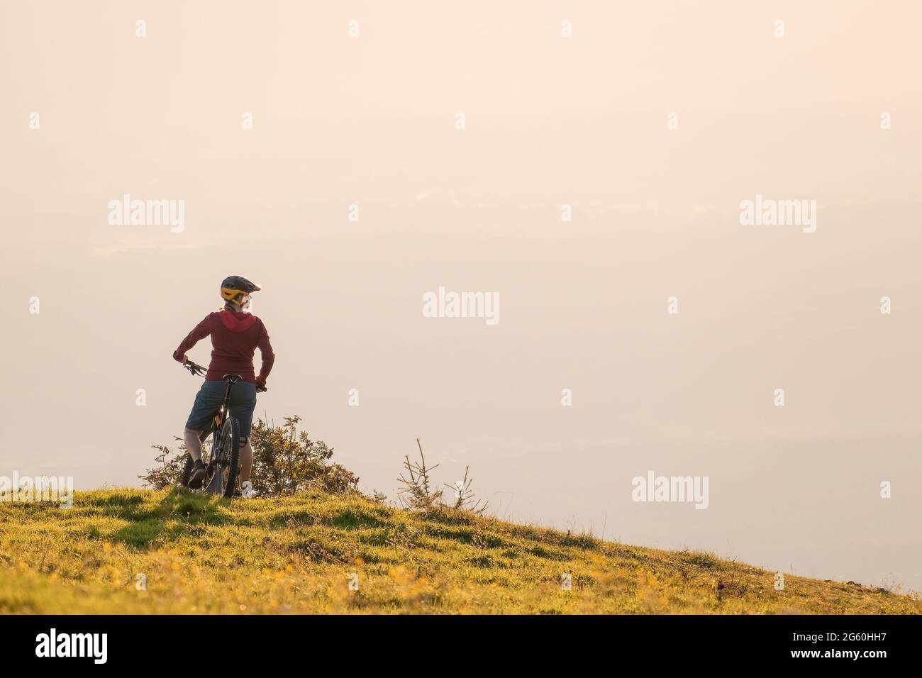 Wide shot, back view of silhouette sitting on a mountain bike, enjoying ...