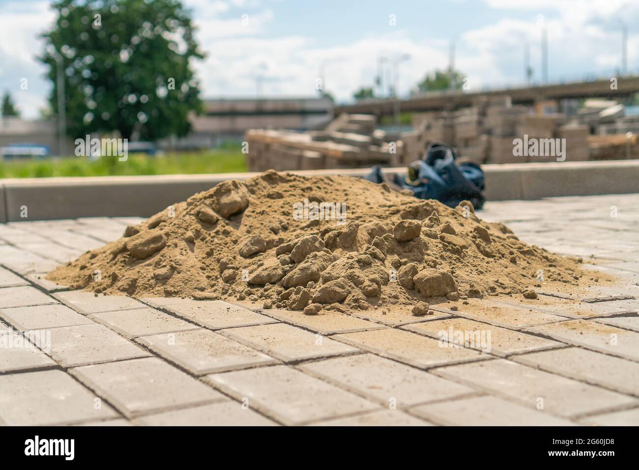 Close-up of a pile of sand lying on the new sidewalk to seal the seams ...