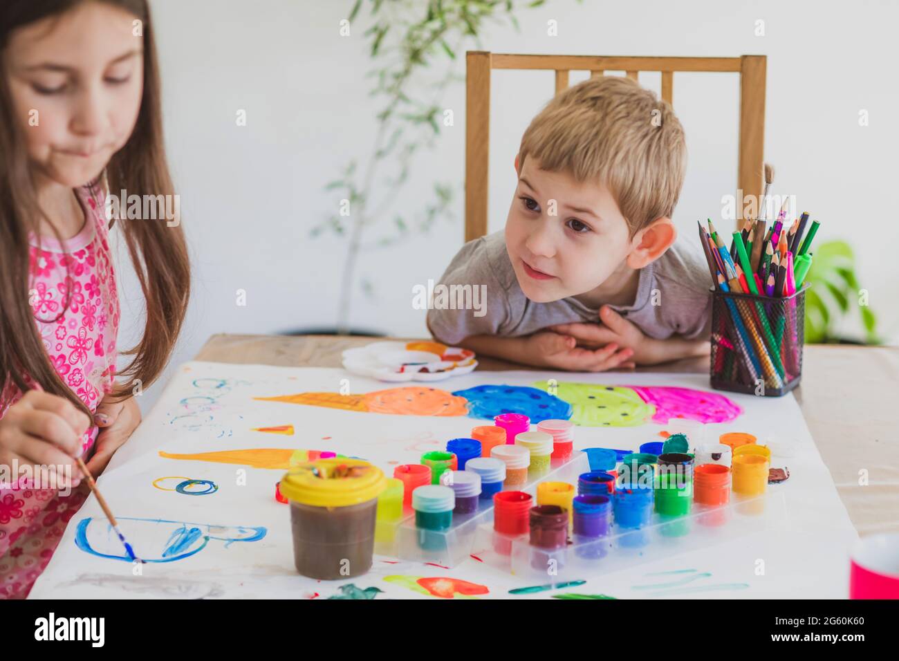 The kids are happy to draw with paints on large paper Stock Photo - Alamy