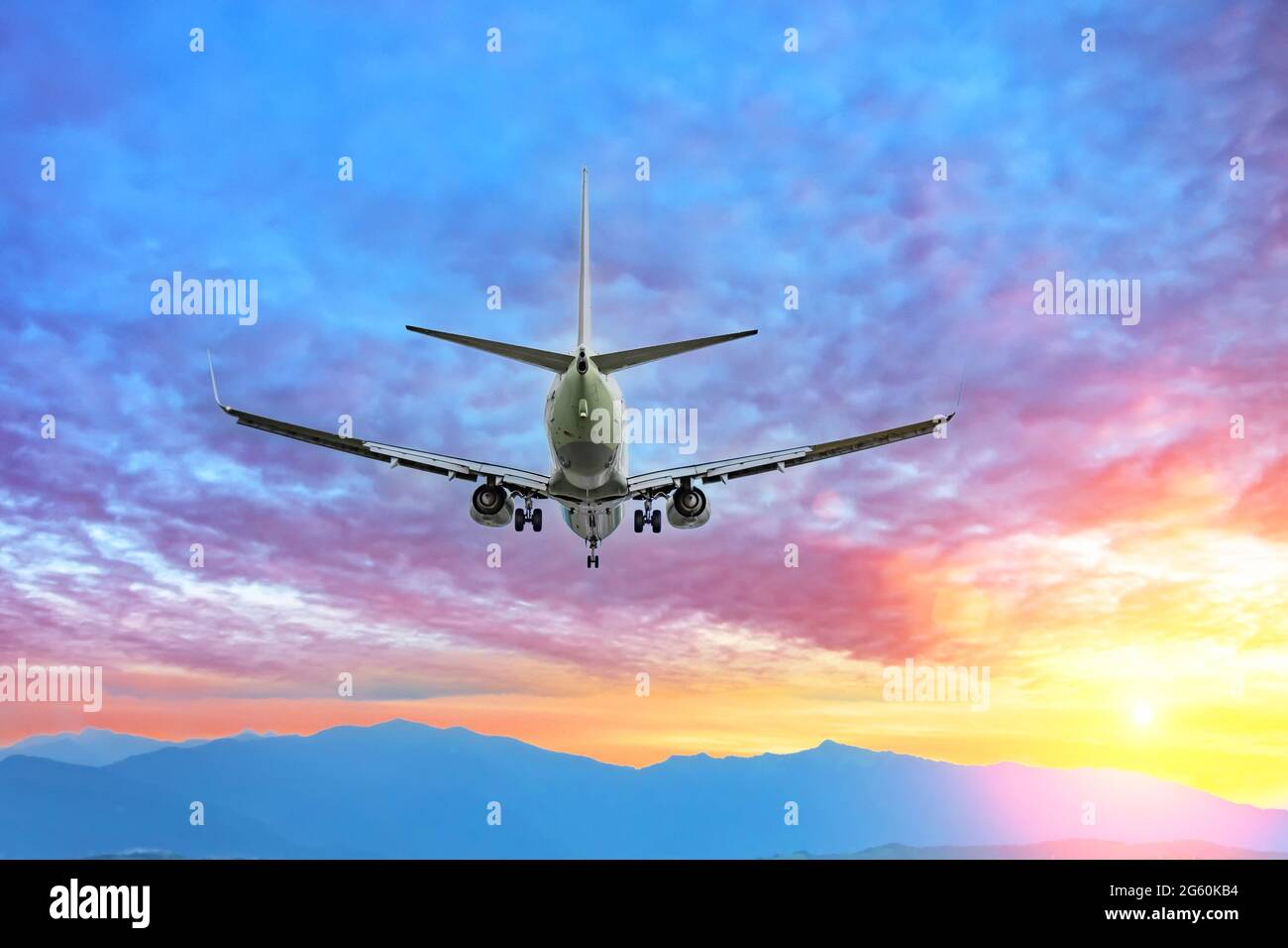 Flying plane over the mountains during a beautiful sunset Stock Photo ...