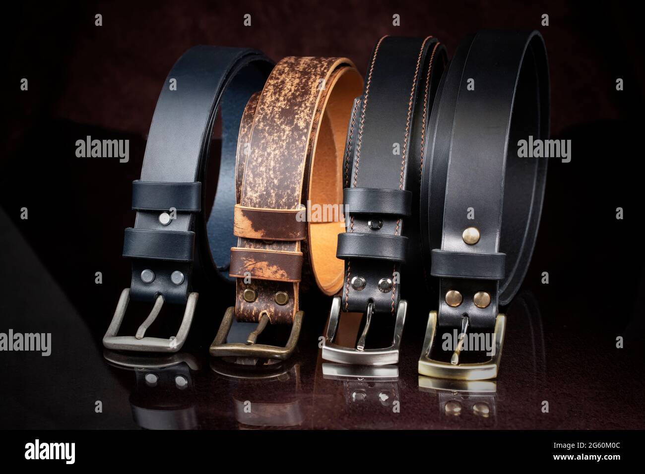 Group of leather belts on a dark background Stock Photo - Alamy