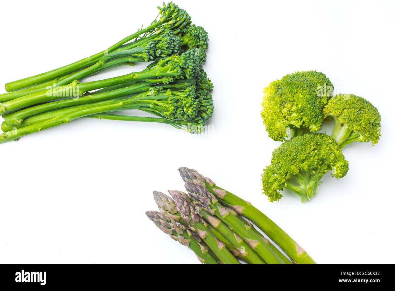 Raw broccolini at the row on white background Stock Photo - Alamy