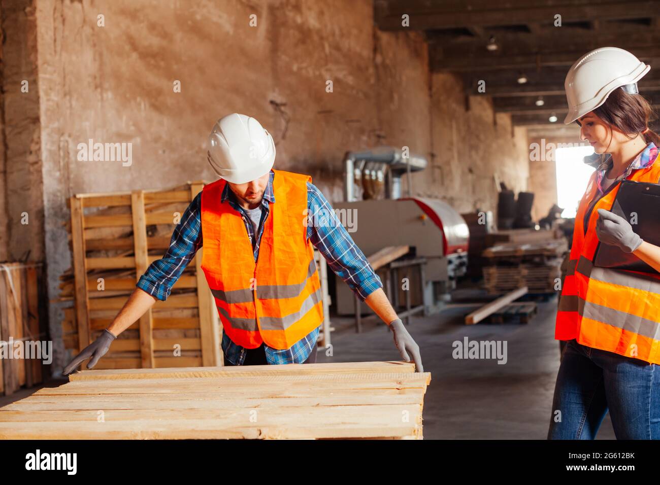 The woman inspector checks the work of a man in a warehouse Stock Photo ...