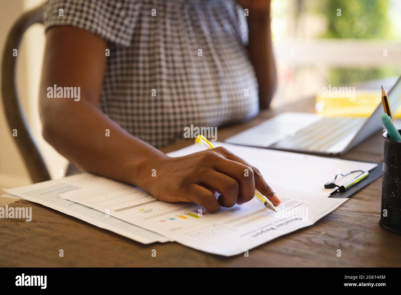 Midsection of african american woman working in living room using ...