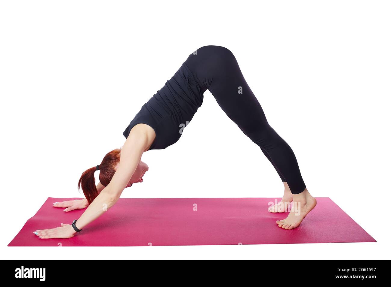A beautiful slender woman performs a Dolphin exercise on a gym mat ...