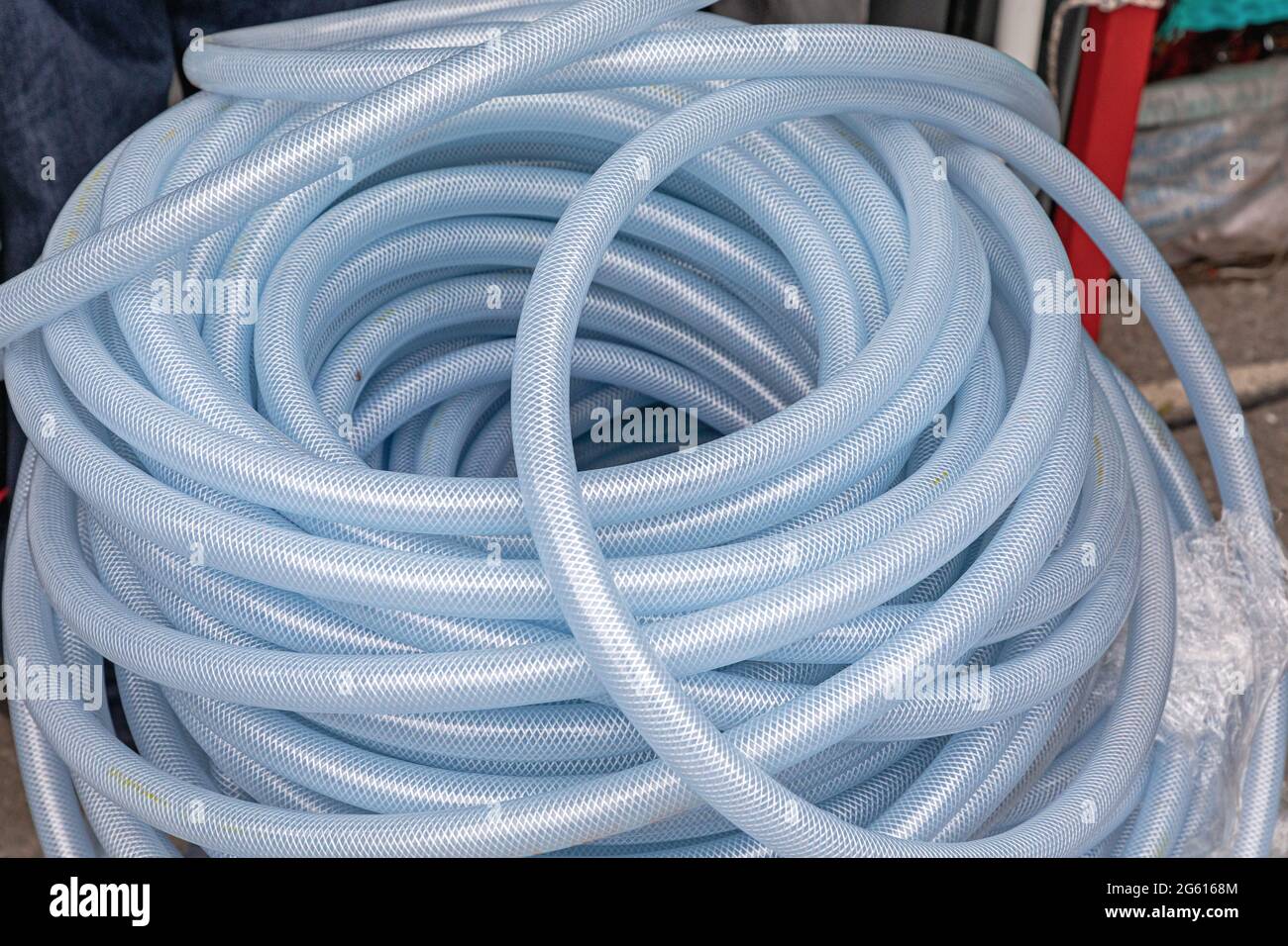 New Long White Plastic Water Hose in Roll Stock Photo - Alamy