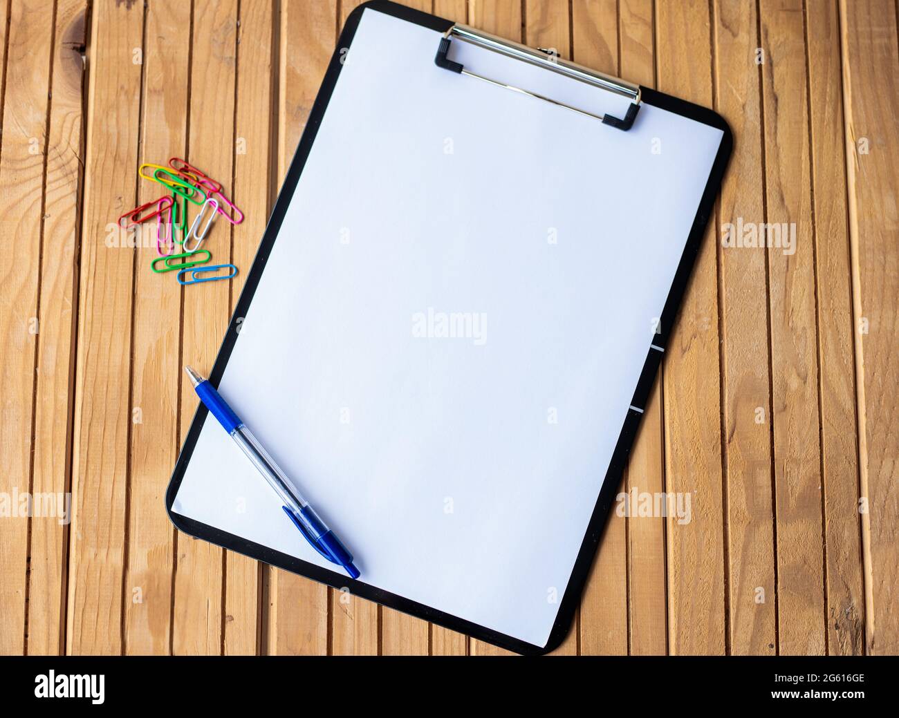 Plain Office Clipboard With Stack Of Pens In A Holder On Top Of A Table ...
